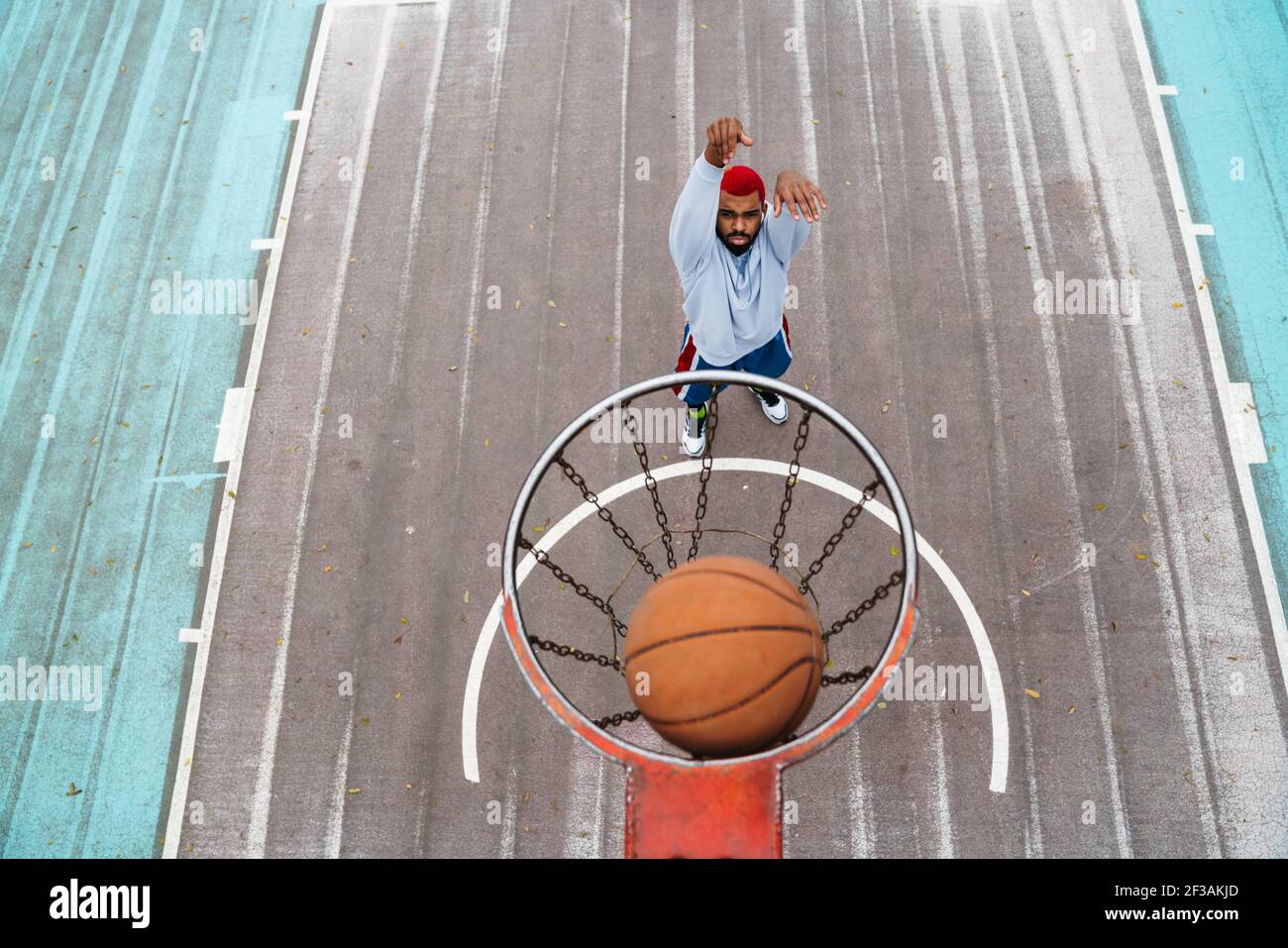 Bearded african american guy in earphones playing basketball at ...