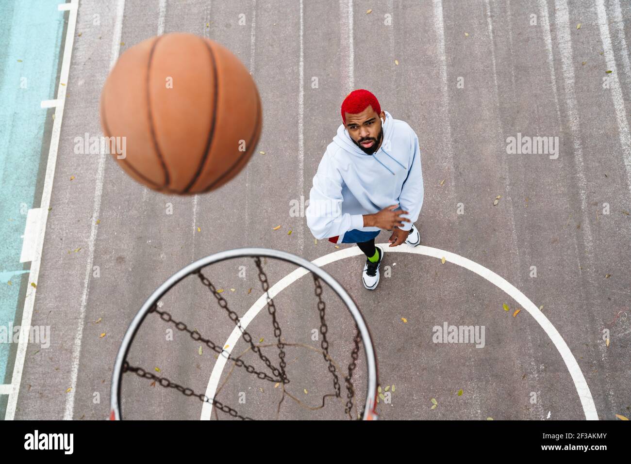 Bearded african american guy in earphones playing basketball at ...