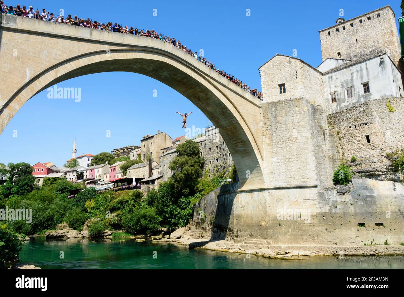 Tourists gathering on the Stari Most (old bridge) to watch a diver jump ...
