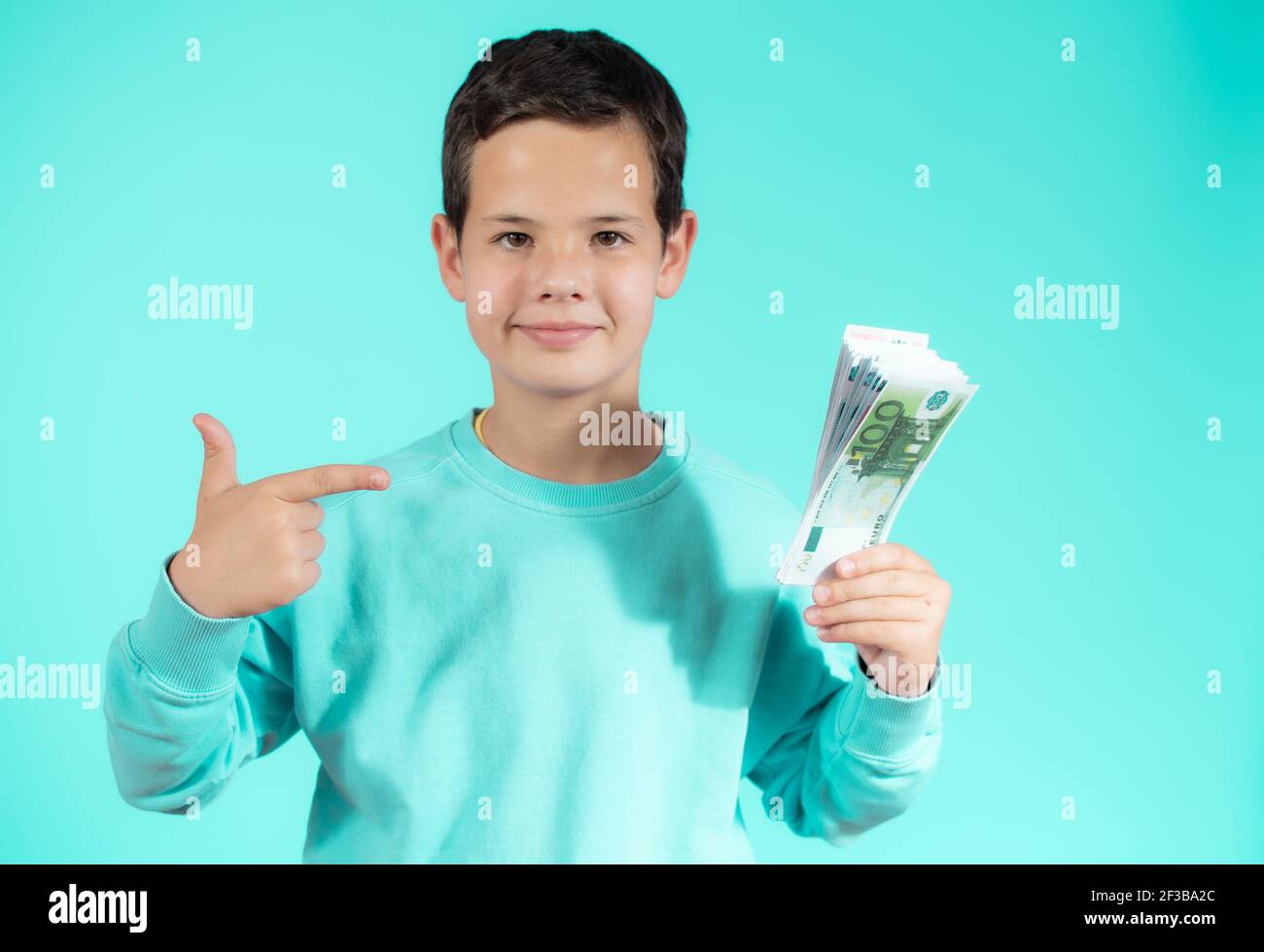 Surprised little boy with money cash. Cute kid hiding face behind fan ...