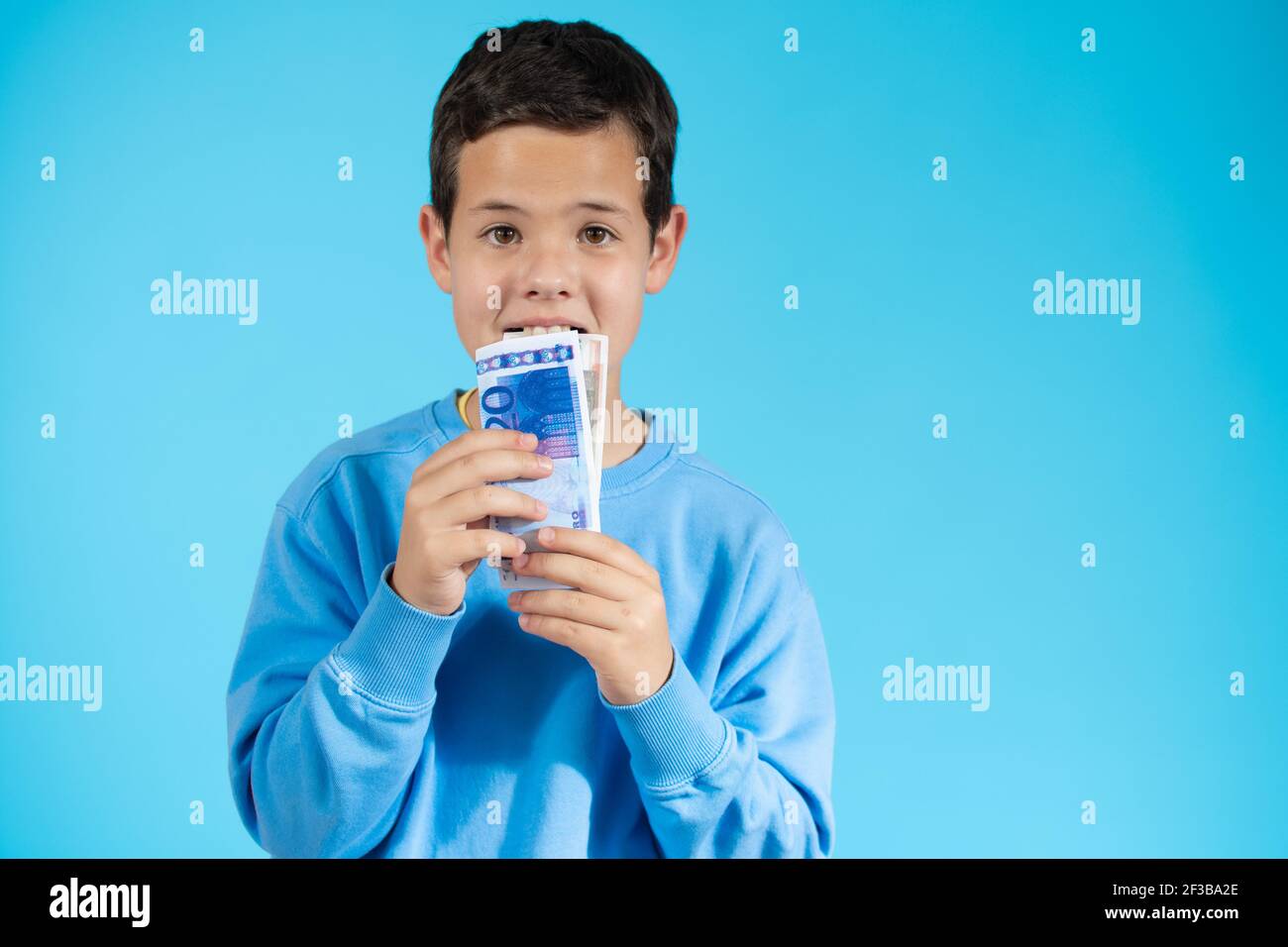 Surprised little boy with money cash. Cute kid hiding face behind fan ...