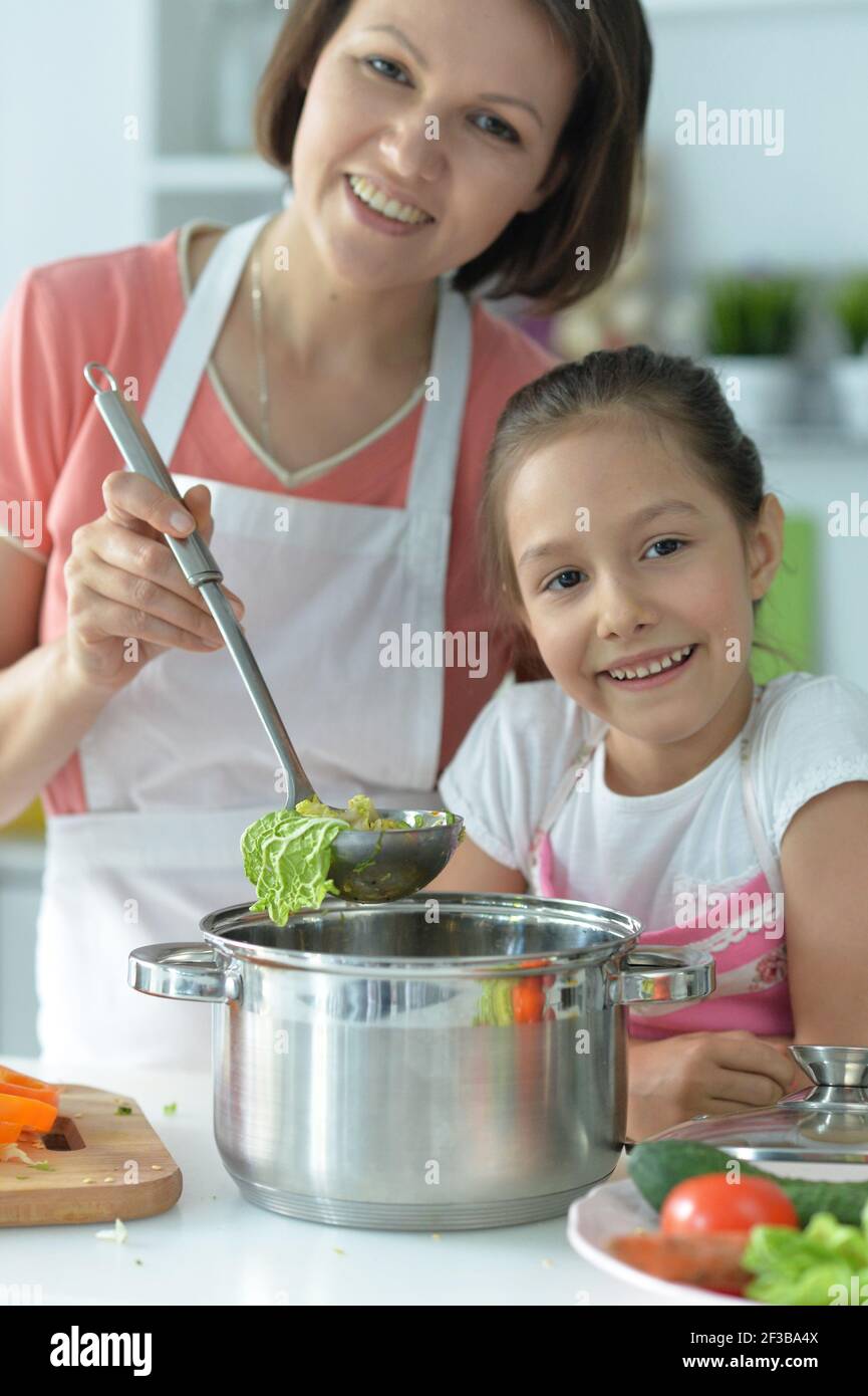 Girl with her mother cooking together at kitchen table Stock Photo - Alamy