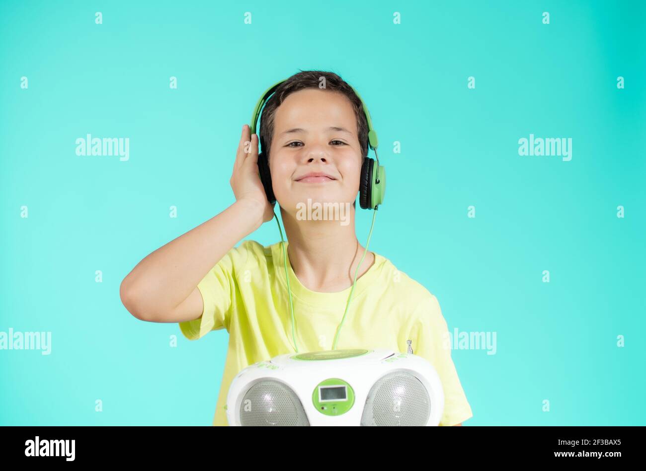 Young boy with headphones and radio over green background Stock Photo ...