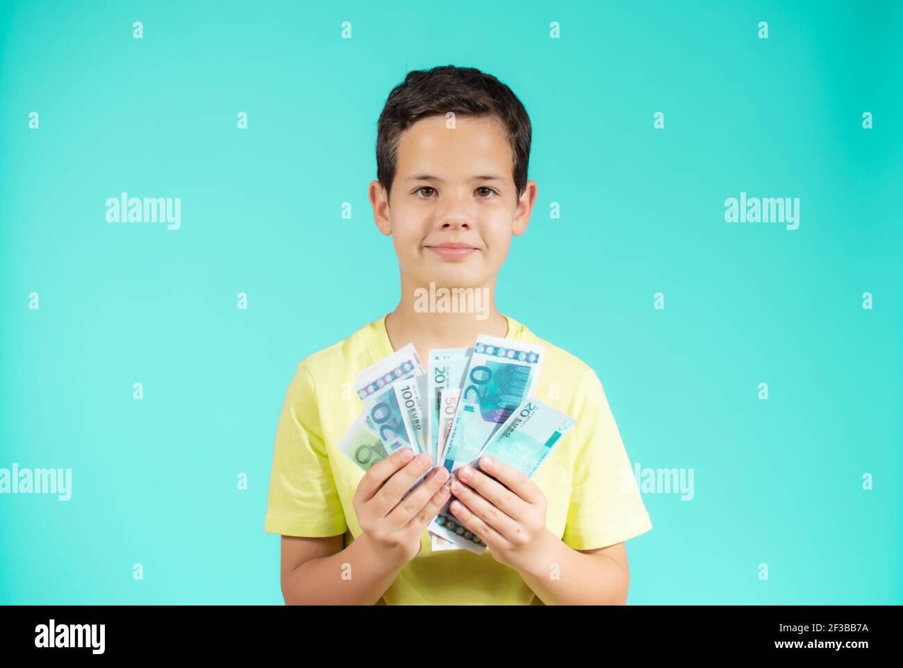 Surprised little boy with money cash. Cute kid hiding face behind fan ...