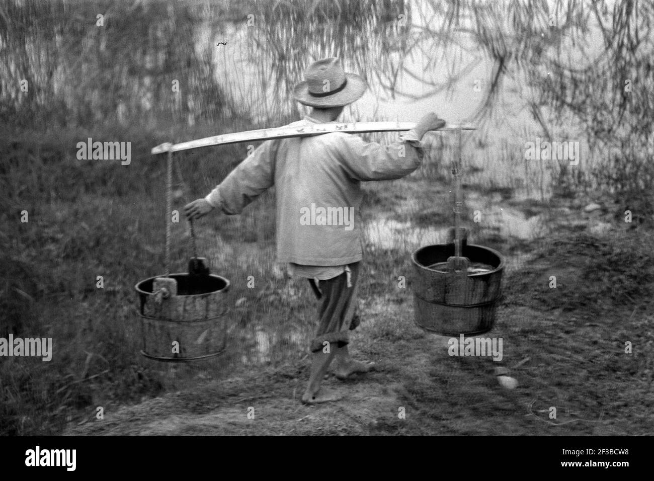 Carrying a bucket Black and White Stock Photos & Images - Alamy