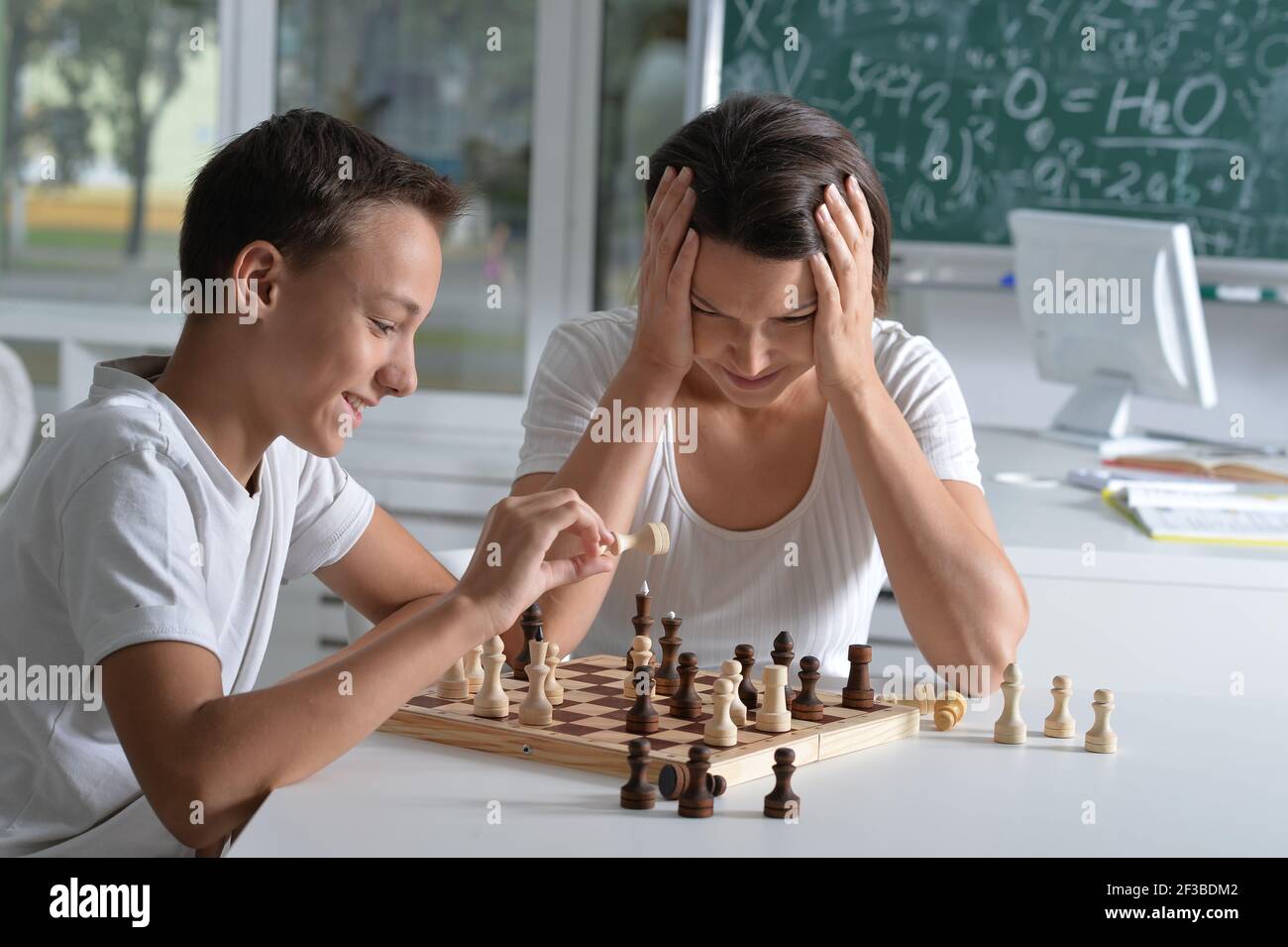 Portrait of teacher and boy playing chess Stock Photo - Alamy