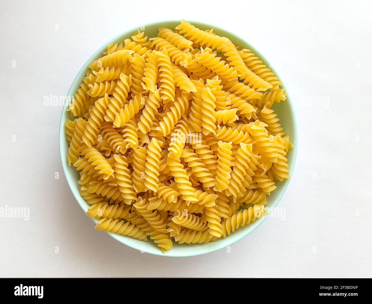 Raw dry Italian pasta in shape of spiral in bowl on wooden table at ...