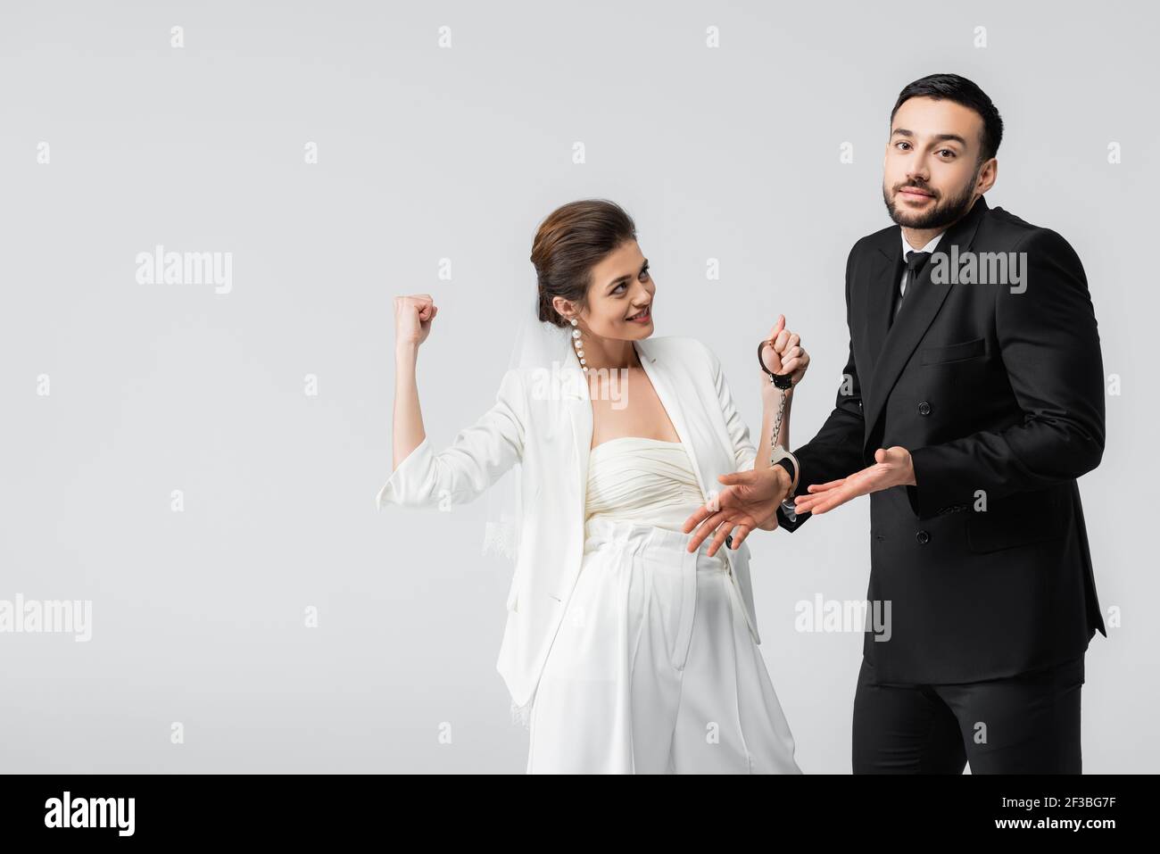 Bride showing yes gesture near arabian boyfriend in handcuffs showing ...