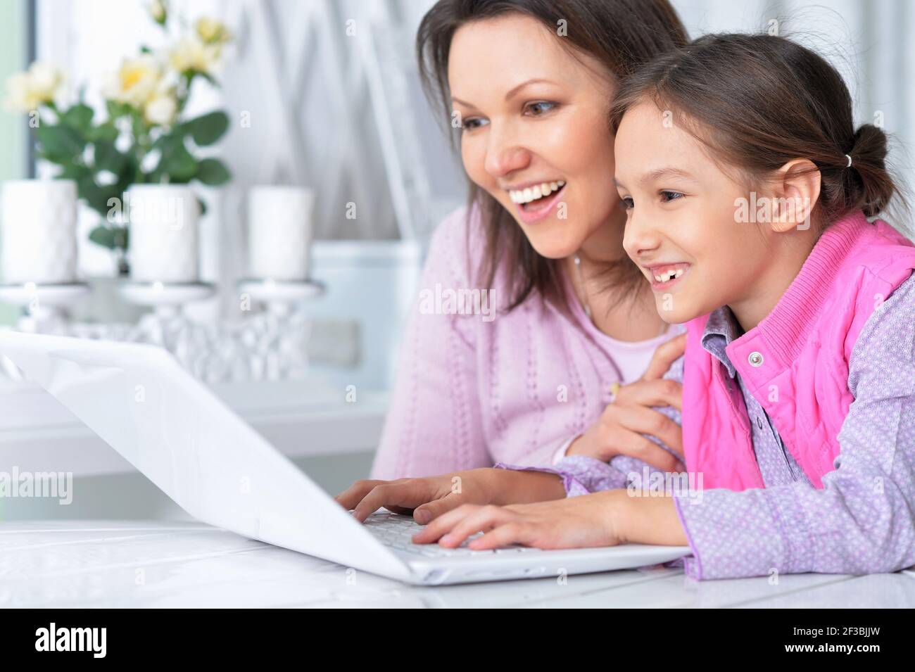 Happy mother and daughter using laptop together Stock Photo - Alamy