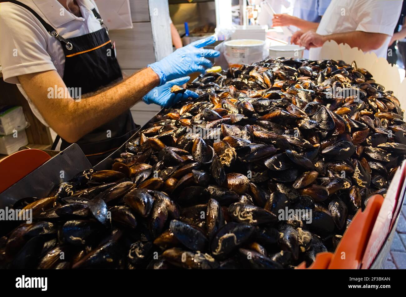 Heap of mussels in shells stuffed with rice and served with lemon. Man ...