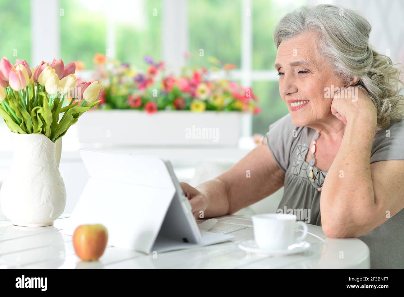 Portrait of beautiful senior woman using modern tablet Stock Photo - Alamy