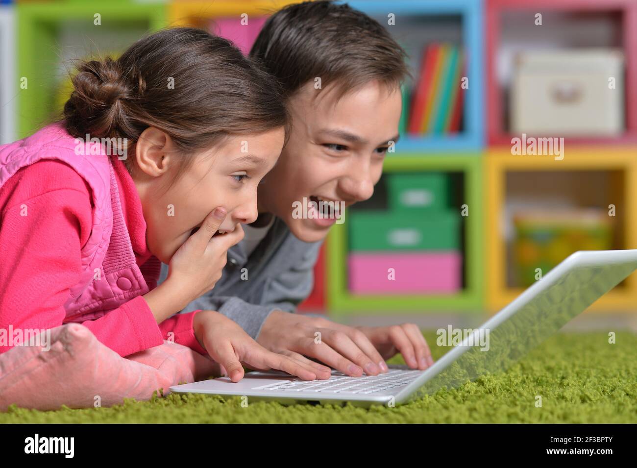 Happy brother and sister using modern laptop Stock Photo - Alamy