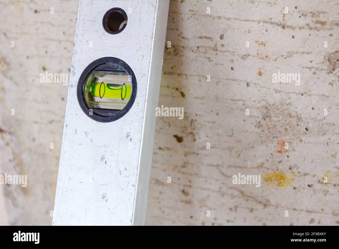 Spirit level placed next to the concrete wall, pillar after usage for ...
