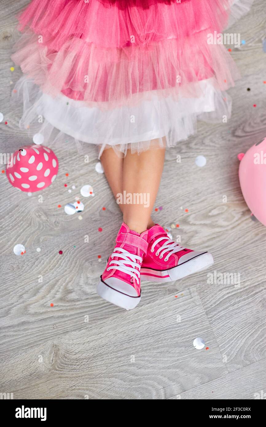 Creative lay out of funky leg of girl in pink sneakers and dress, flat ...
