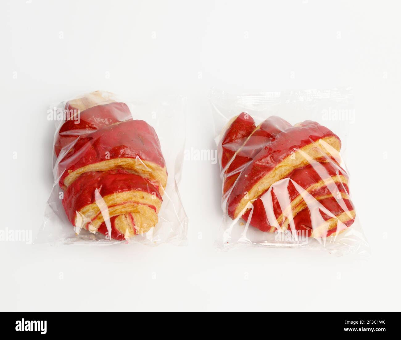 baked croissants with cherry glaze in a transparent plastic bag, white ...
