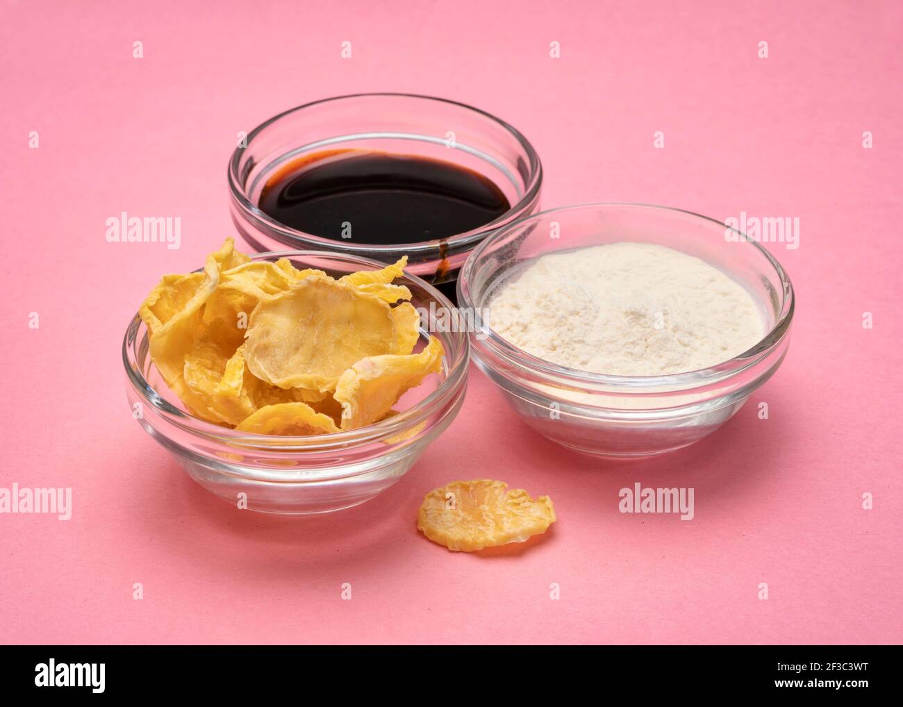 Dried slices of yacon tuber, syrup and powder in small glass bowls ...