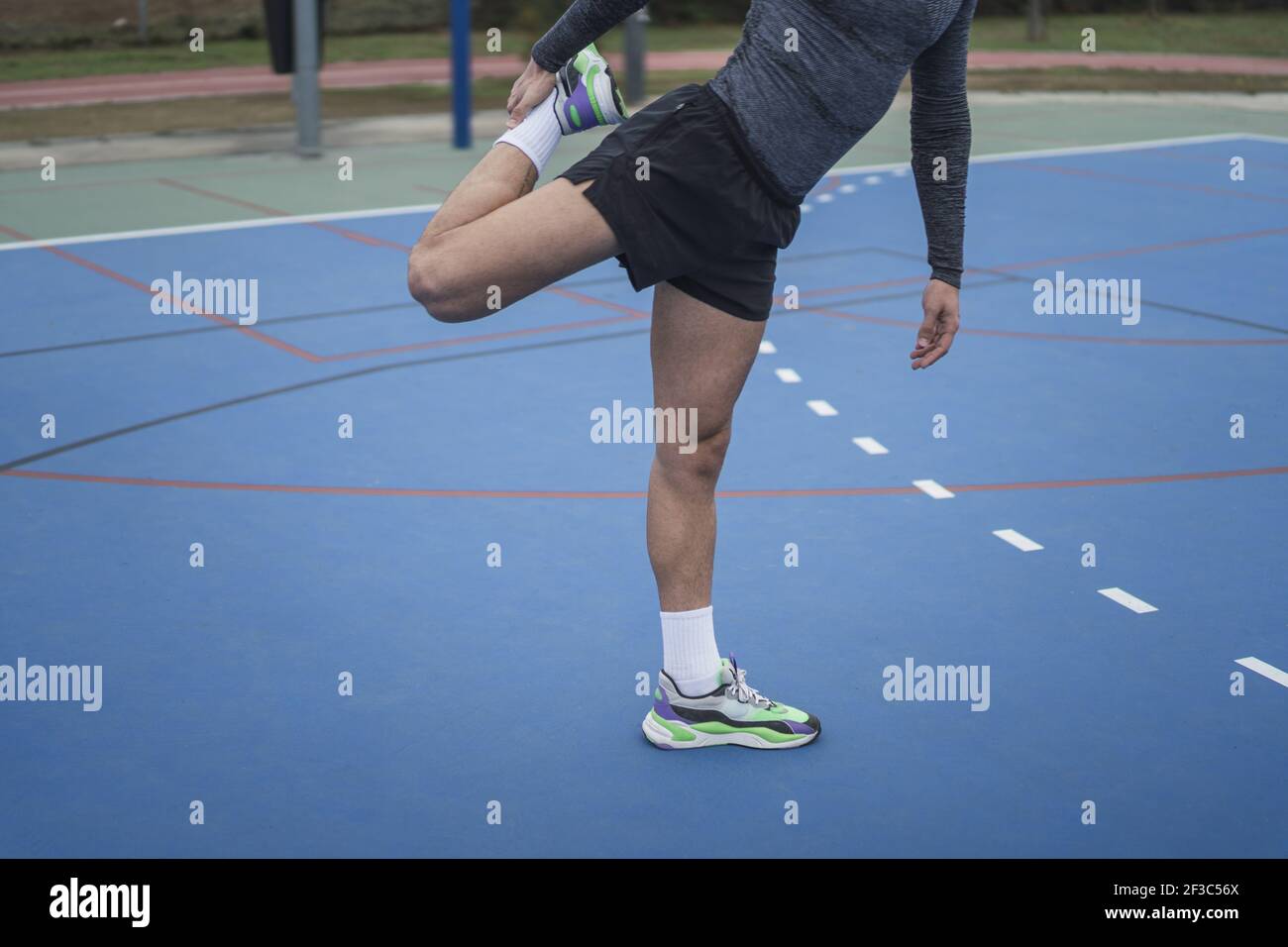 A muscular athlete stretching the leg while doing a workout Stock Photo ...
