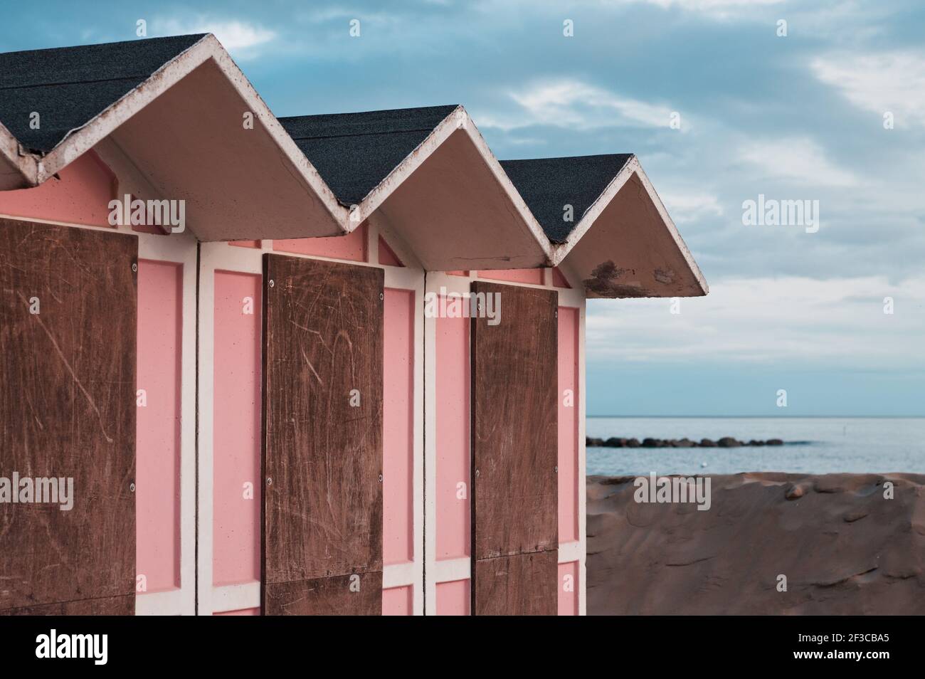 Pink beach cabins in the bathhouse on the sand with Mediterranean sea ...
