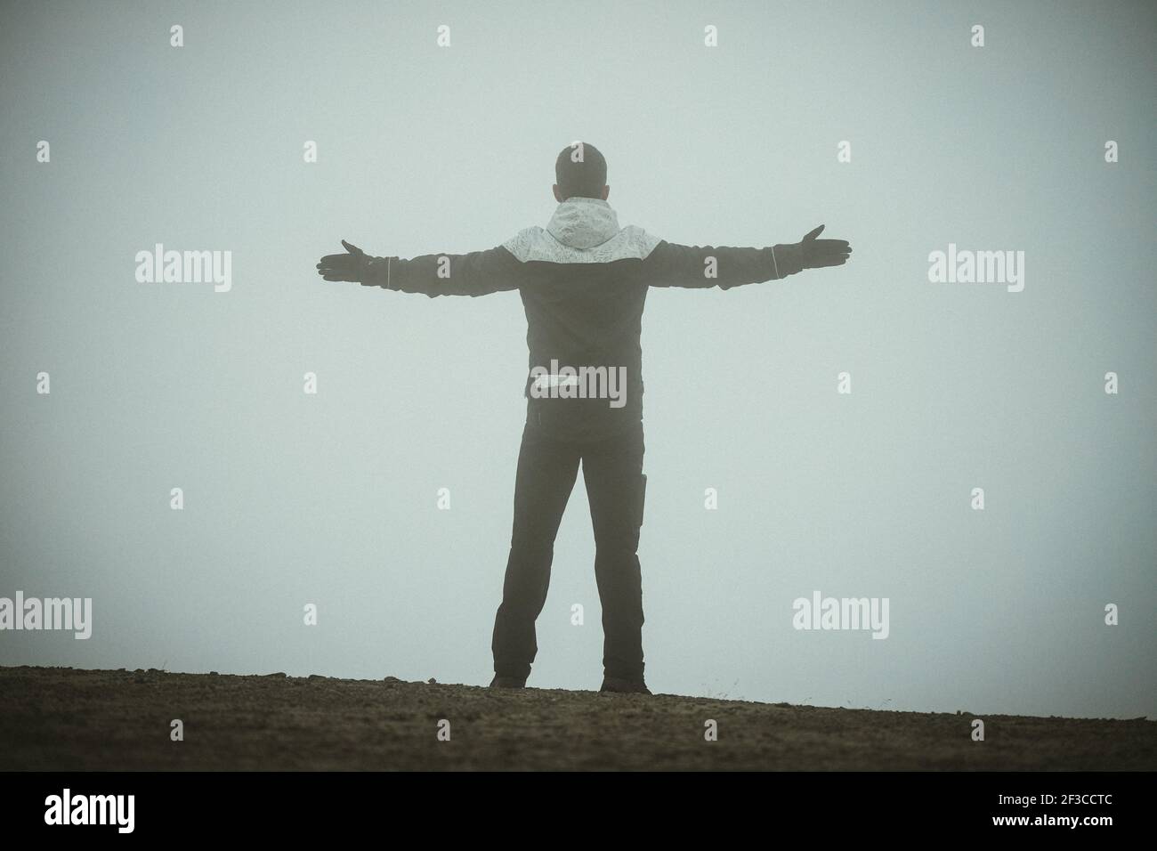 A young man spreading his arms and enjoying the morning mist Stock ...