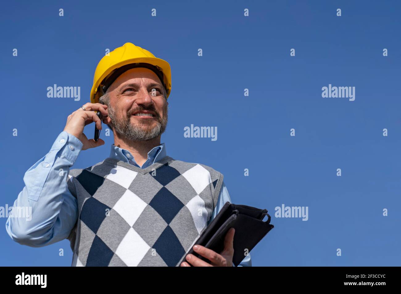 Smiling Business Person in Yellow Hardhat Talking on Mobile Phone Stock ...