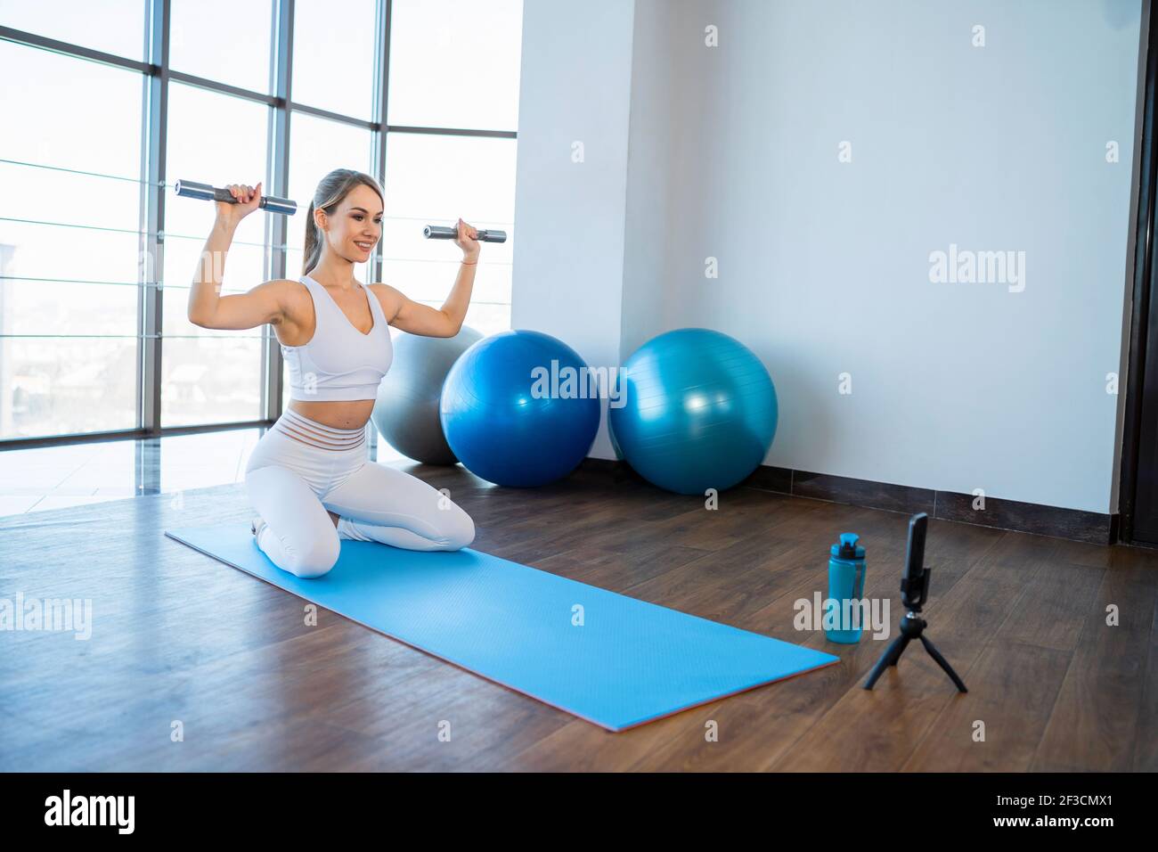 Female sports coach records online video tutorials on fitness classes ...