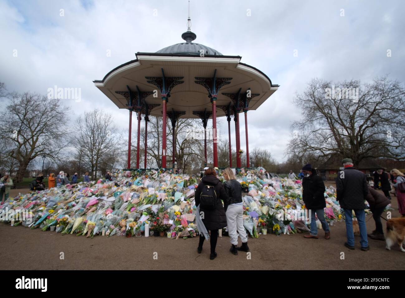 London, UK. 16th March, 2021. Mourners place flowers on the bandstand ...