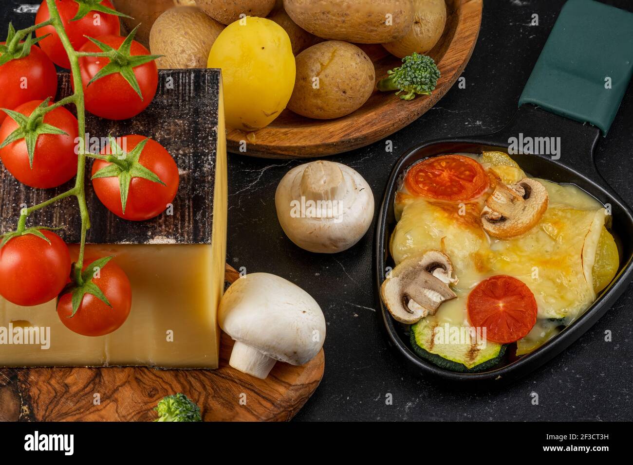 Delicious traditional Swiss melted raclette cheese on chopped boiled ...