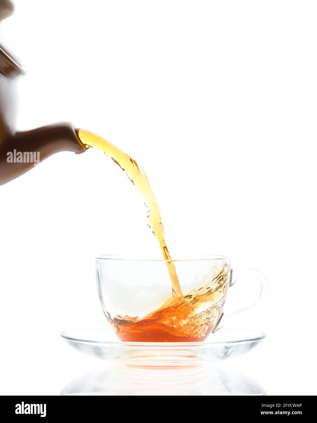 Pouring black tea into transparent cup from teapot Stock Photo - Alamy