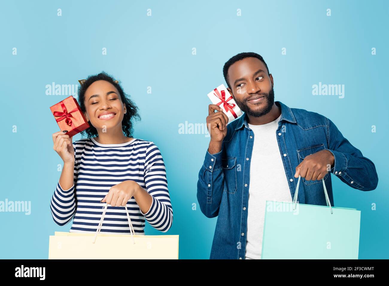 cheerful african american husband and wife holding shopping bags and ...