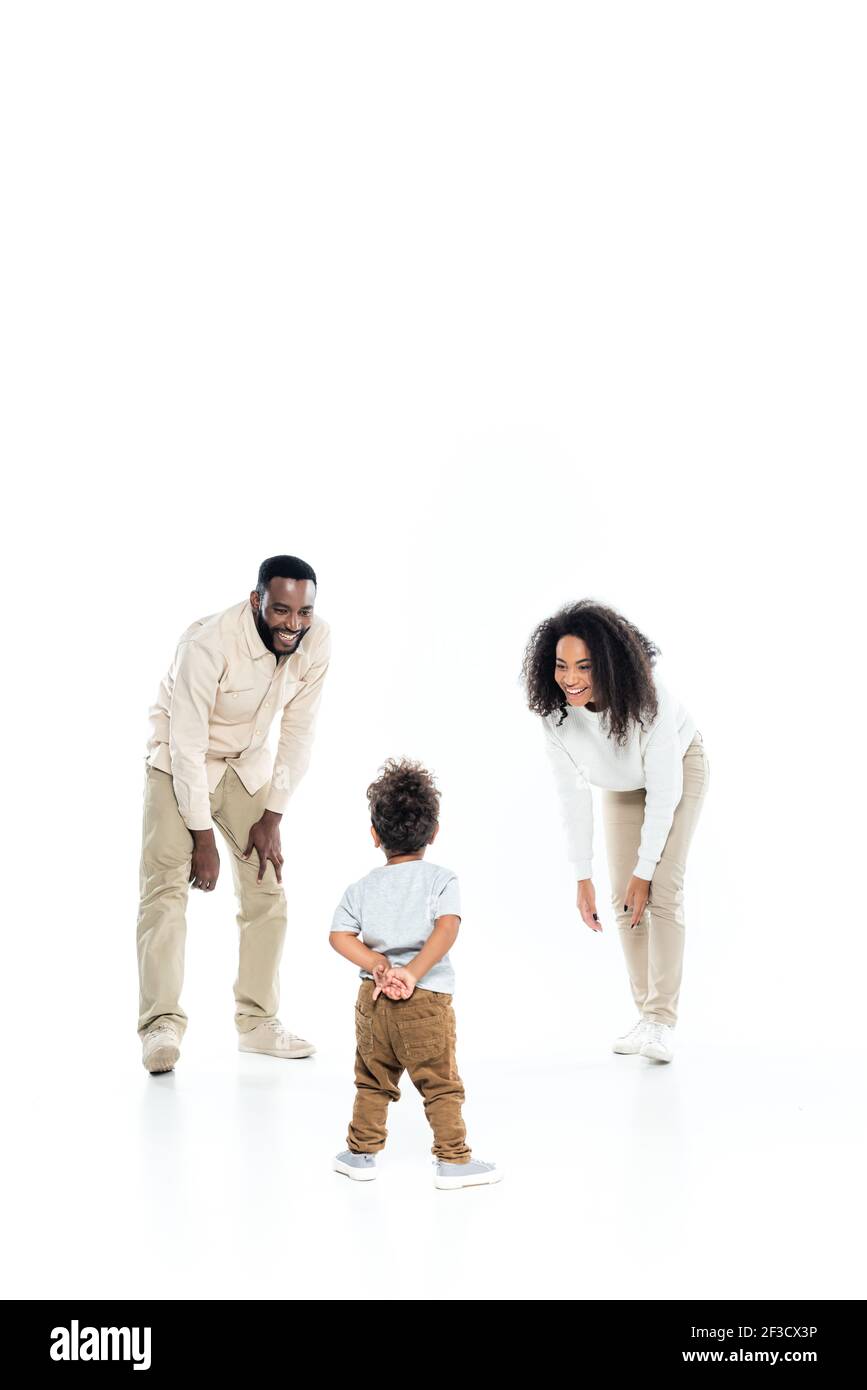 back view of african american kid standing with hands behind back near ...