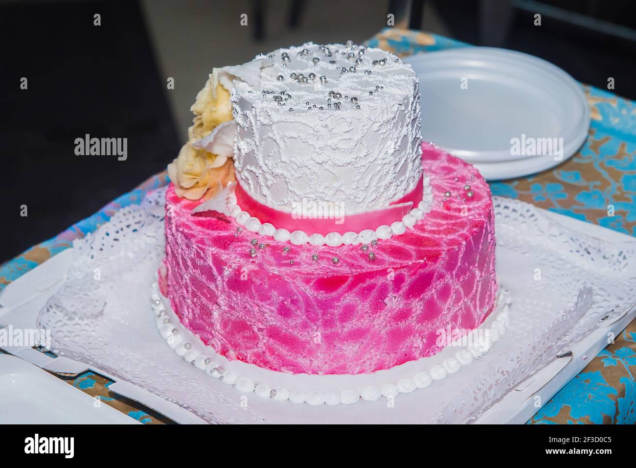 Wedding white and pink two-tier cake with food pearl decoration on a ...