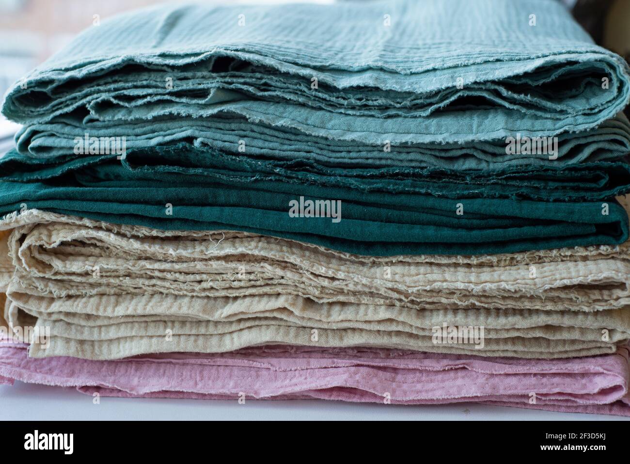 Background from a stack of muslin fabrics. Organic cotton textiles ...