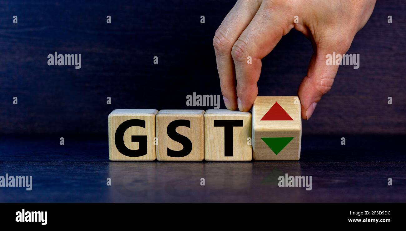 GST, goods and services tax symbol. Businessman holds a cube with up ...
