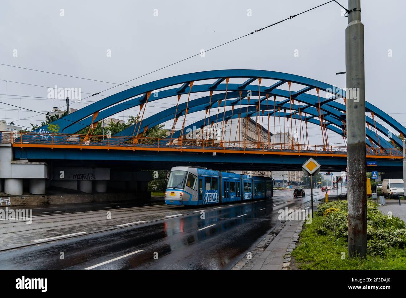 Wroclaw, Poland - May 23 2020: Blue tram drive under the railway bridge ...