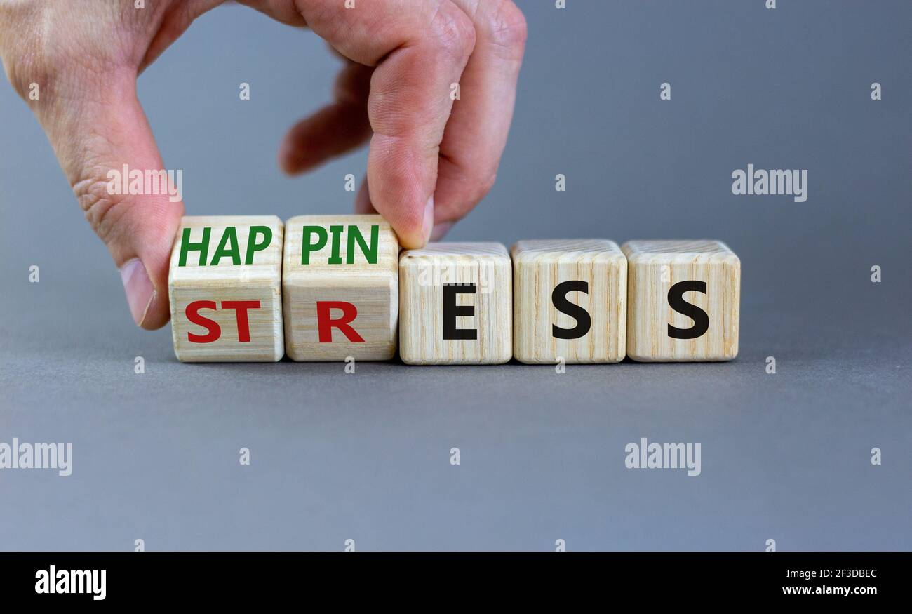 Happiness instead of stress. Businessman turns a cube and changes the ...
