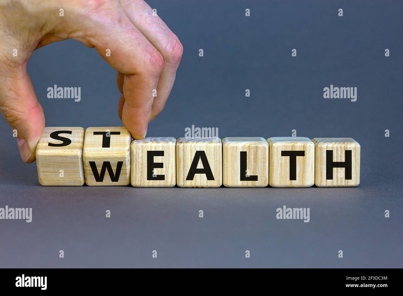 Stealth wealth symbol. Businessman turns wooden cubes and changes the ...
