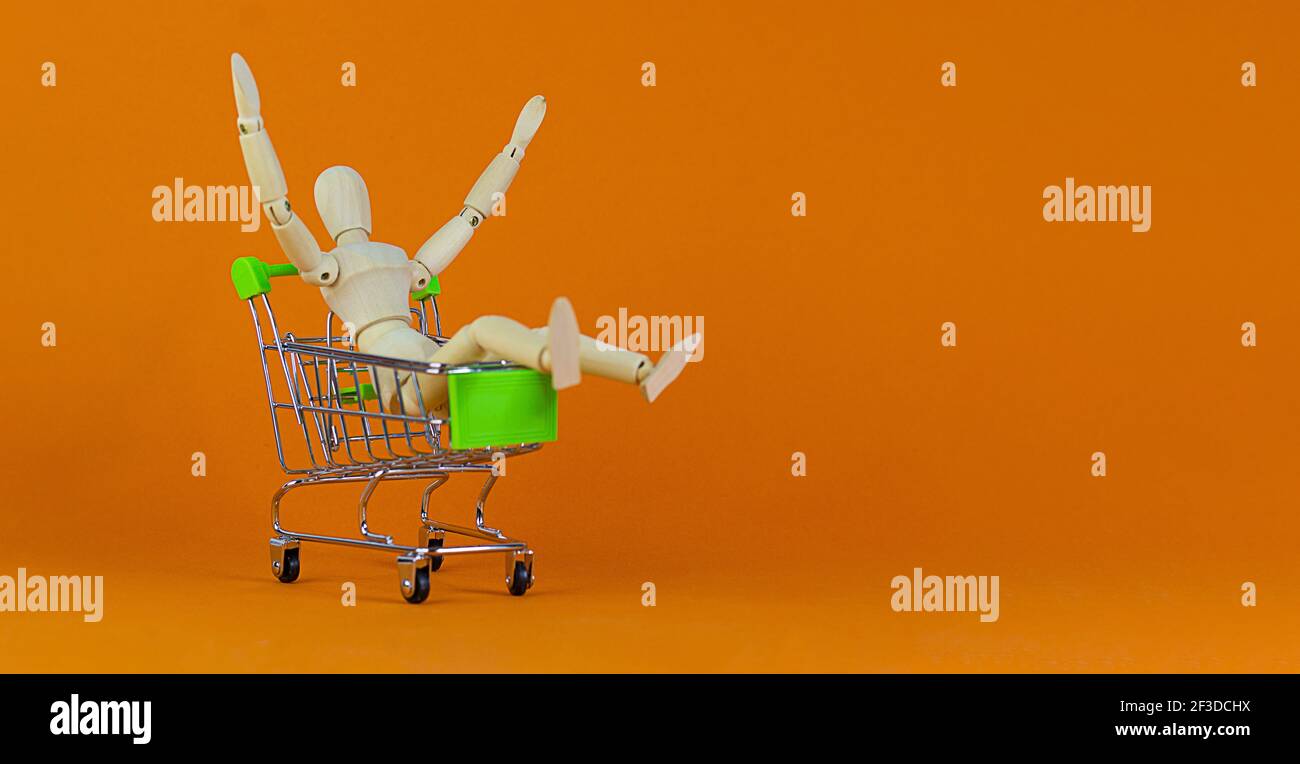 Sale time symbol. Wooden model of a human in a shopping cart. Beautiful ...