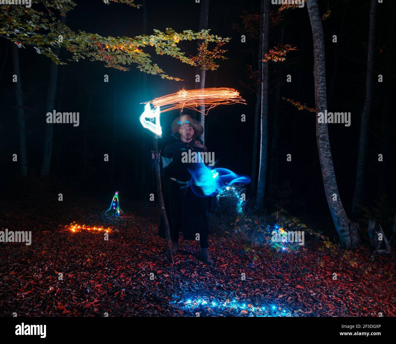Sorcerer (magician) casting a spell while standing in the magical woods ...