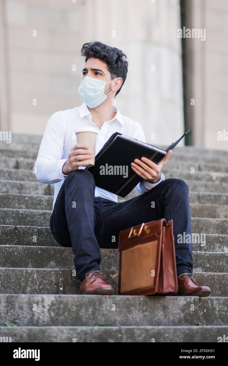 Business man reading files outdoors Stock Photo - Alamy