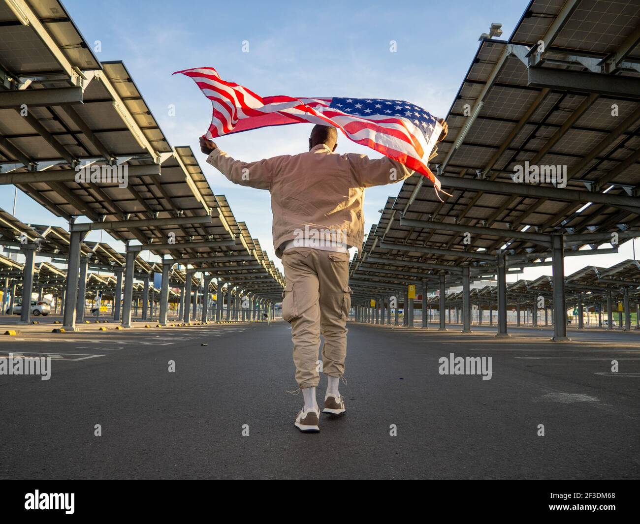An African-American male with hands up holds the flag of the USA behind ...
