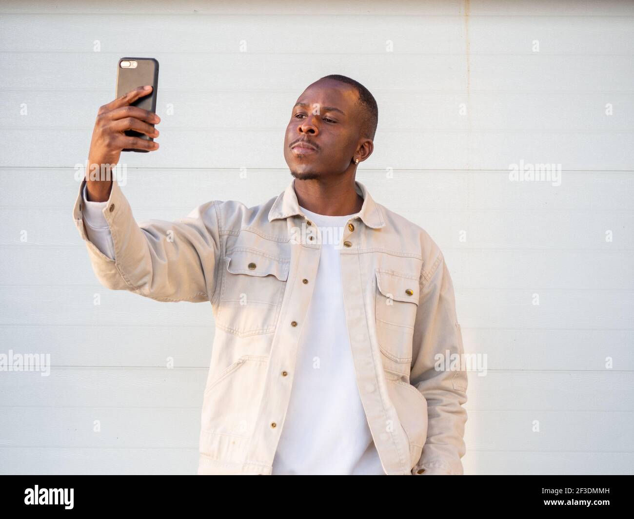 A handsome black Spanish male taking a selfie with his smartphone Stock ...
