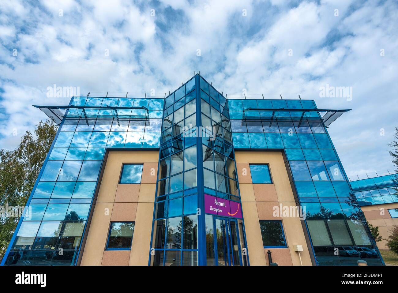 Low angle view of office building in modern design. Glossy glass facade ...