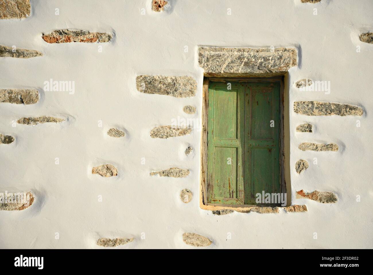Traditional rural adobe house facade with a whitewashed stone wall and ...