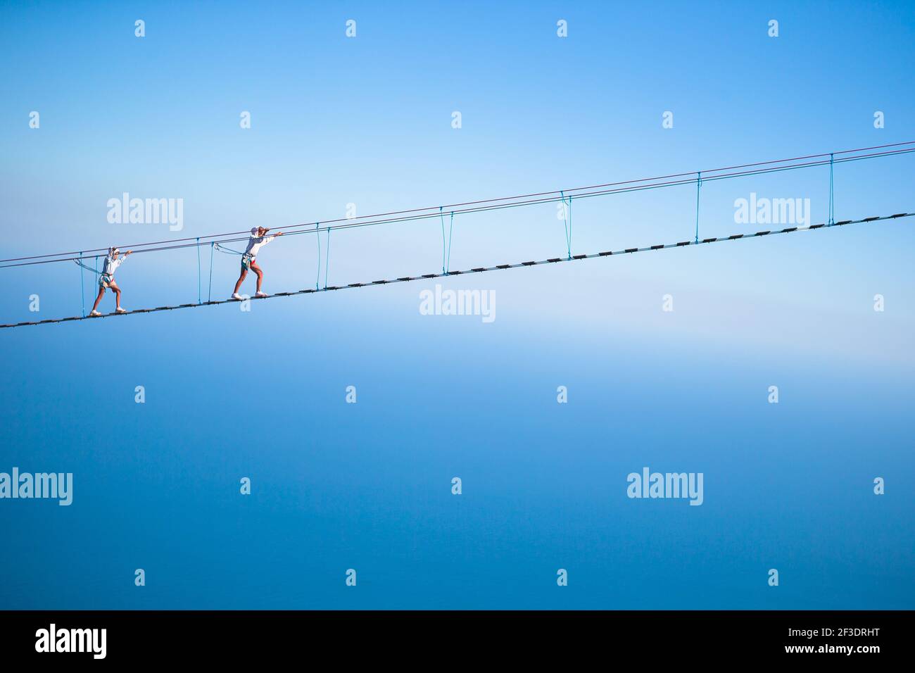 Girls crossing the chasm on the rope bridge Stock Photo - Alamy