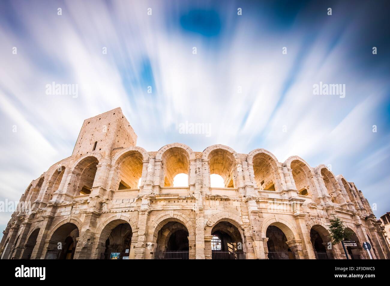 Low angle view on historic Roman arena / Arles Amphitheatre. Oval building surrounded by walls ...