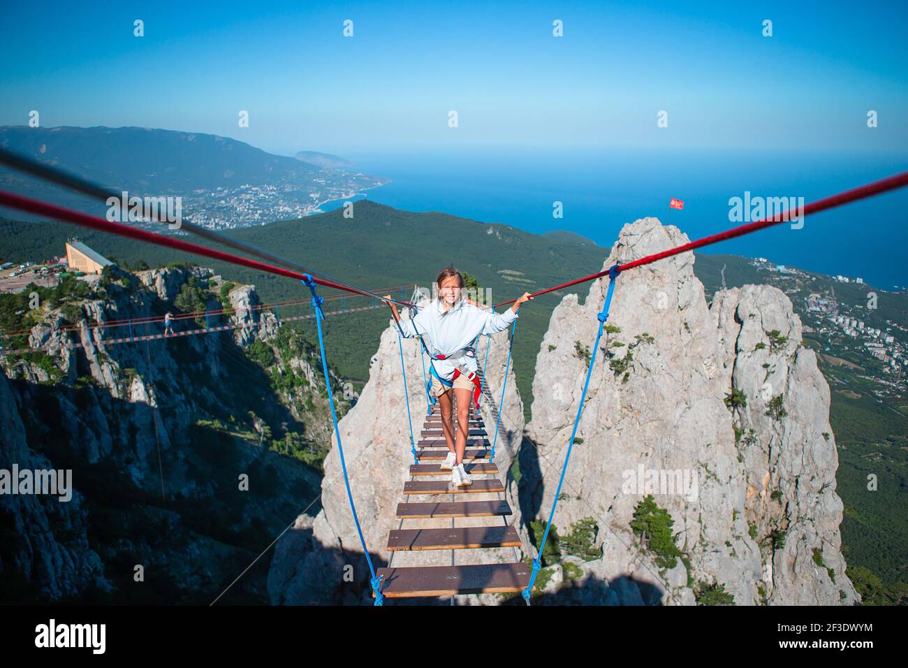 Girls crossing the chasm on the rope bridge Stock Photo - Alamy