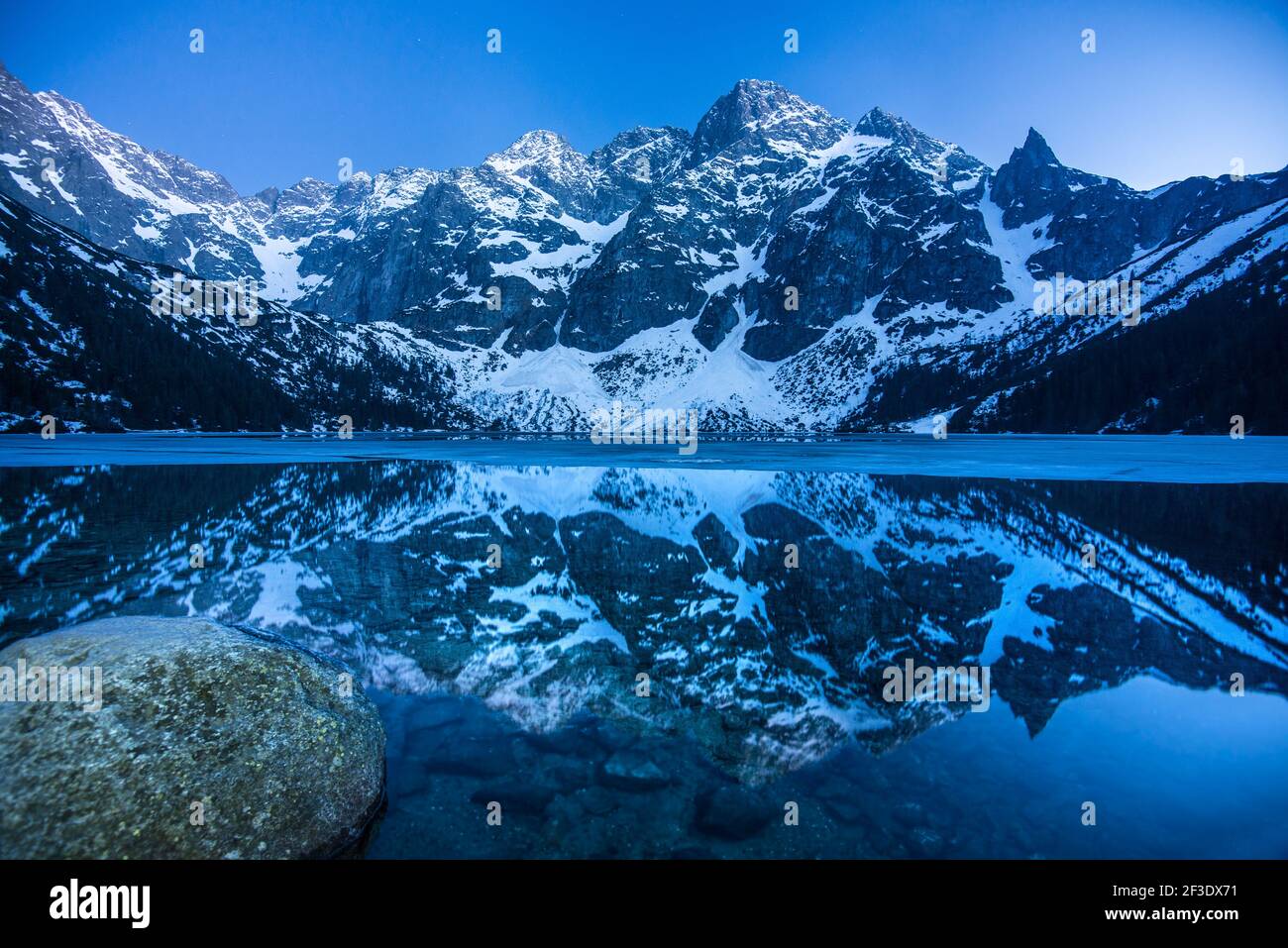 Reflecting Of Sharp Rocky Peaks Dusted With Snow In Eye Of The Sea