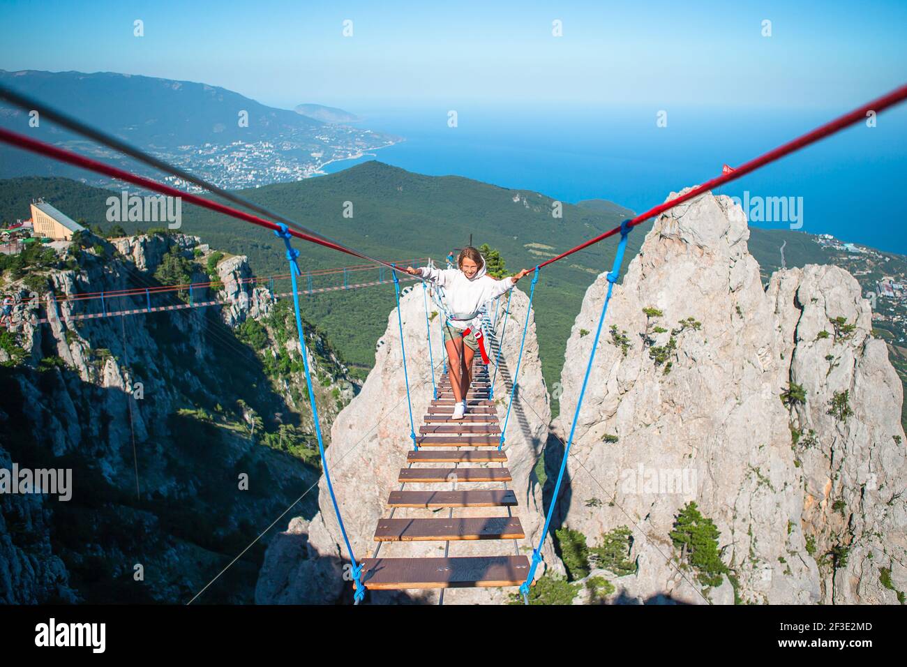 Girls crossing the chasm on the rope bridge Stock Photo - Alamy