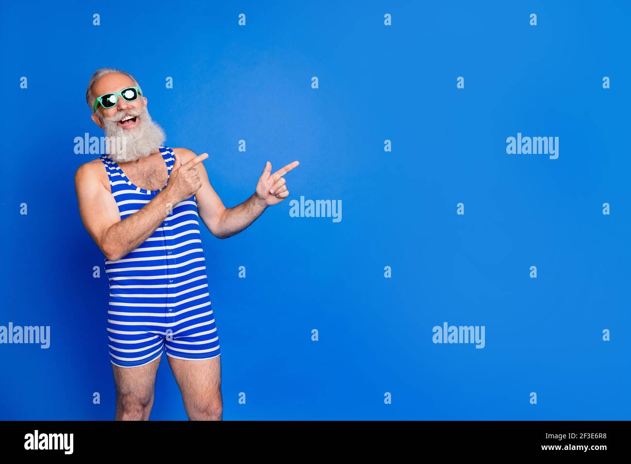 Photo of optimistic grey beard man point empty space wear eyewear blue ...