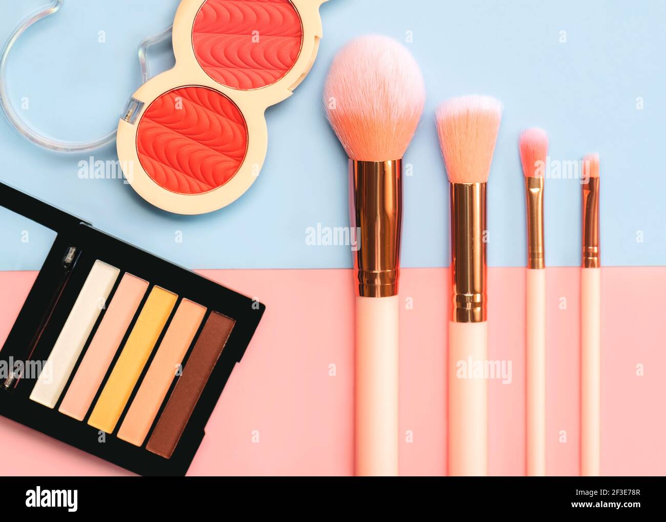 Different makeup female cosmetics and accessories on a pink and blue ...